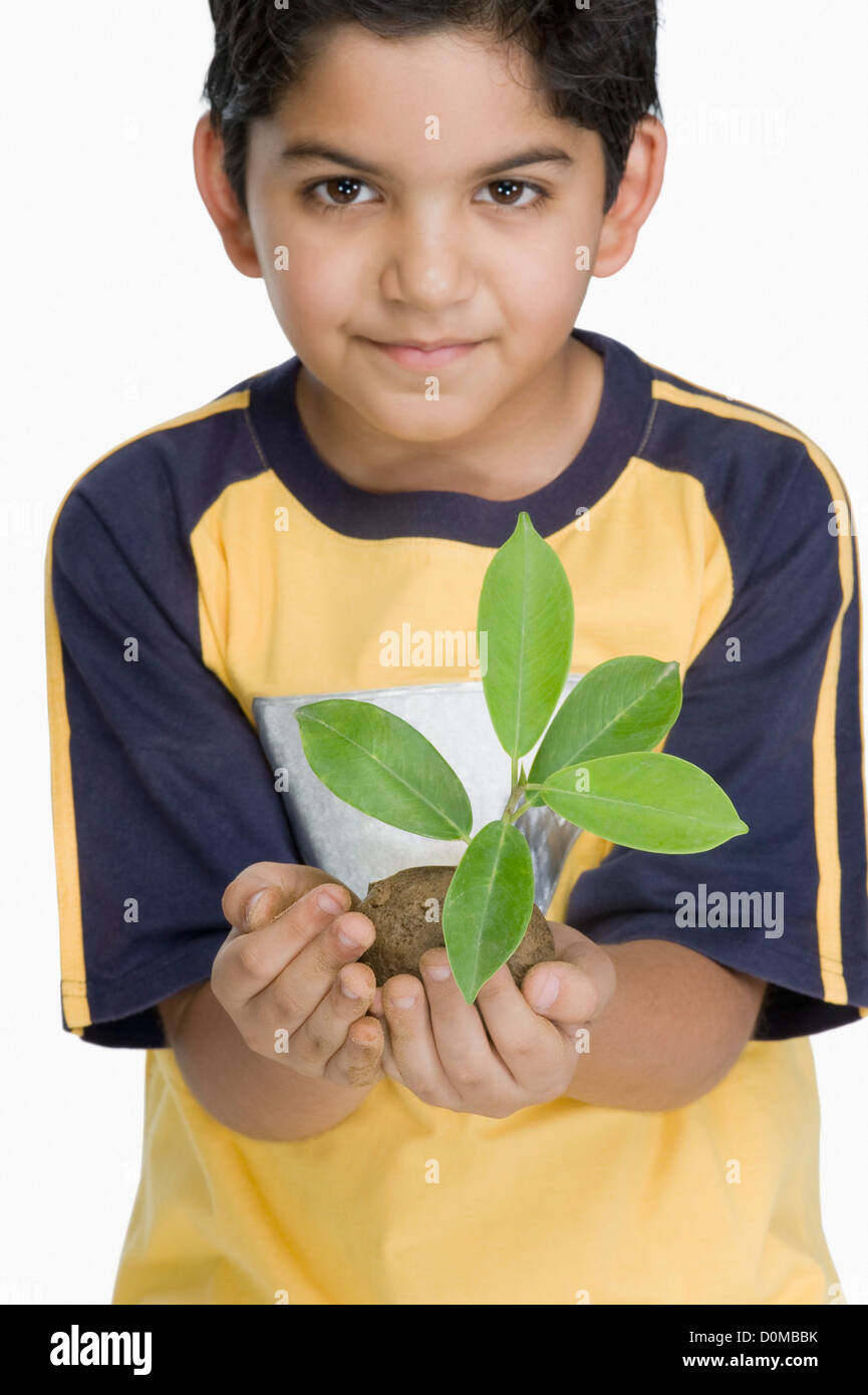 Portrait of a boy holding a plant Stock Photo - Alamy