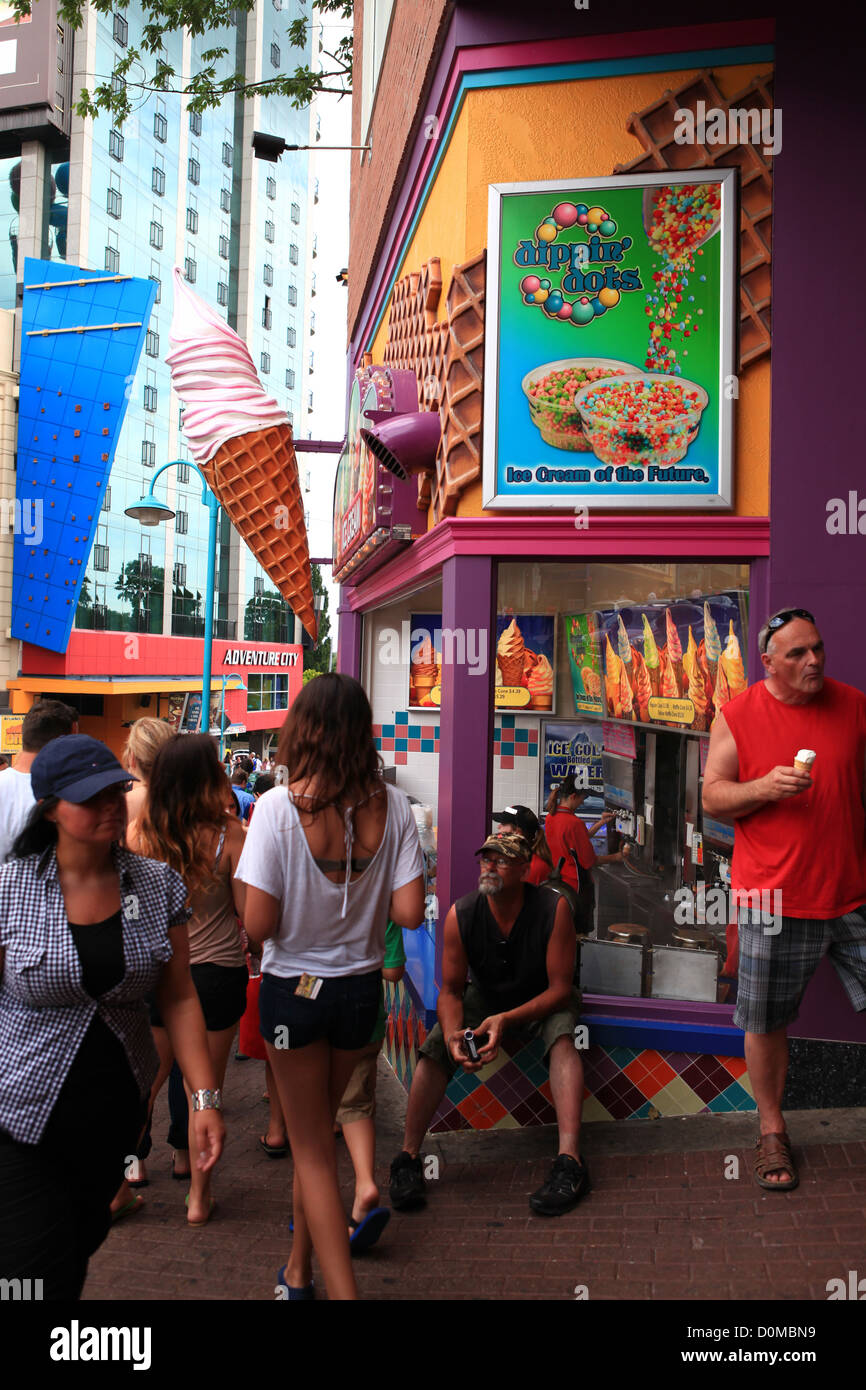 Long line of people waiting outside an ice cream store in summer heat ...