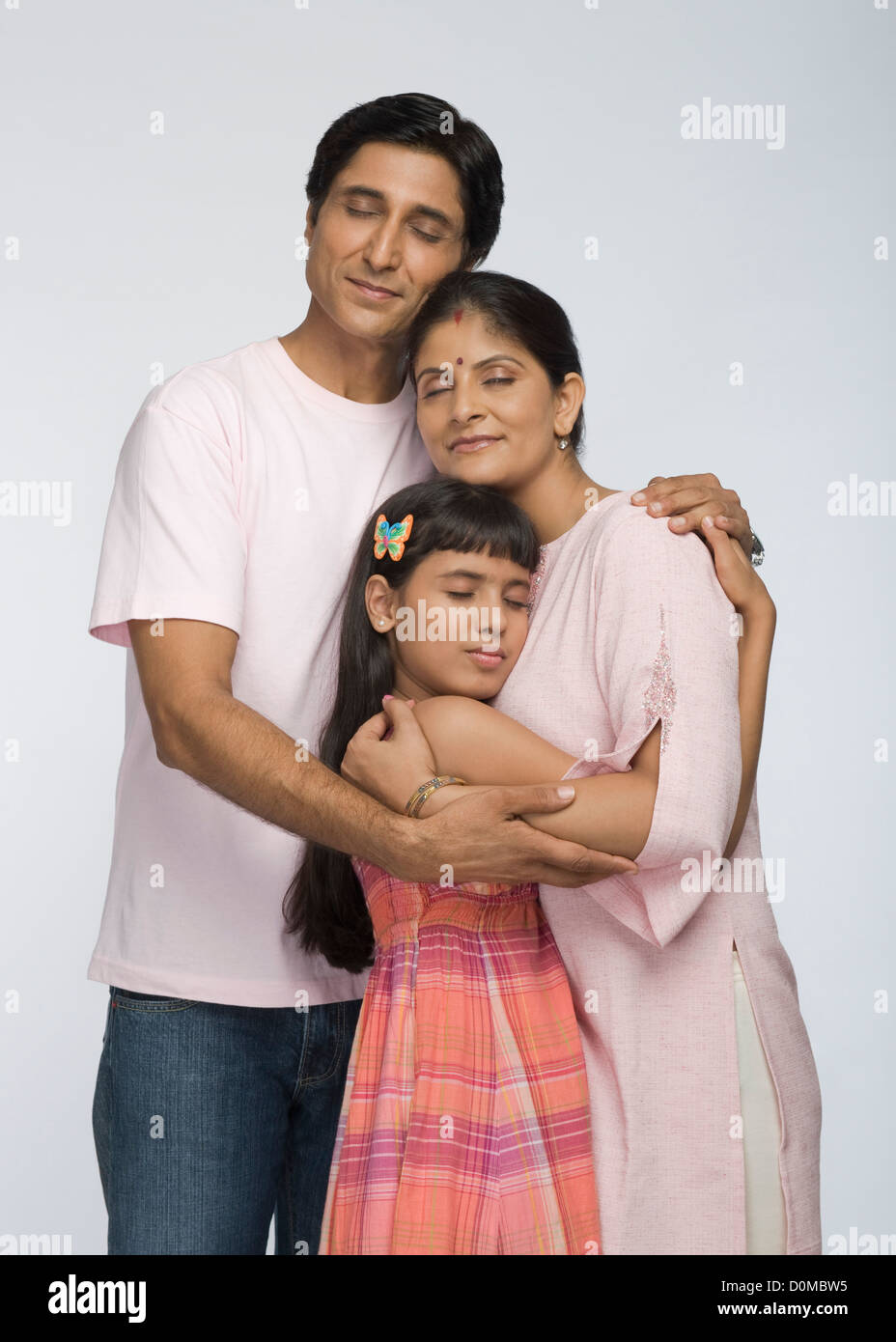 Parents hugging their daughter Stock Photo - Alamy