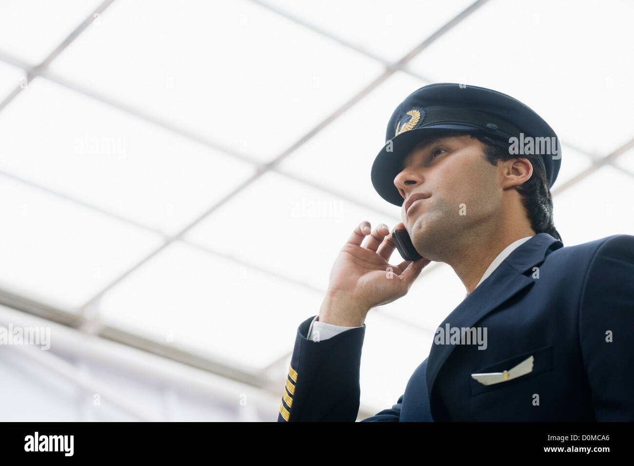 Pilot talking on a mobile phone at an airport Stock Photo - Alamy
