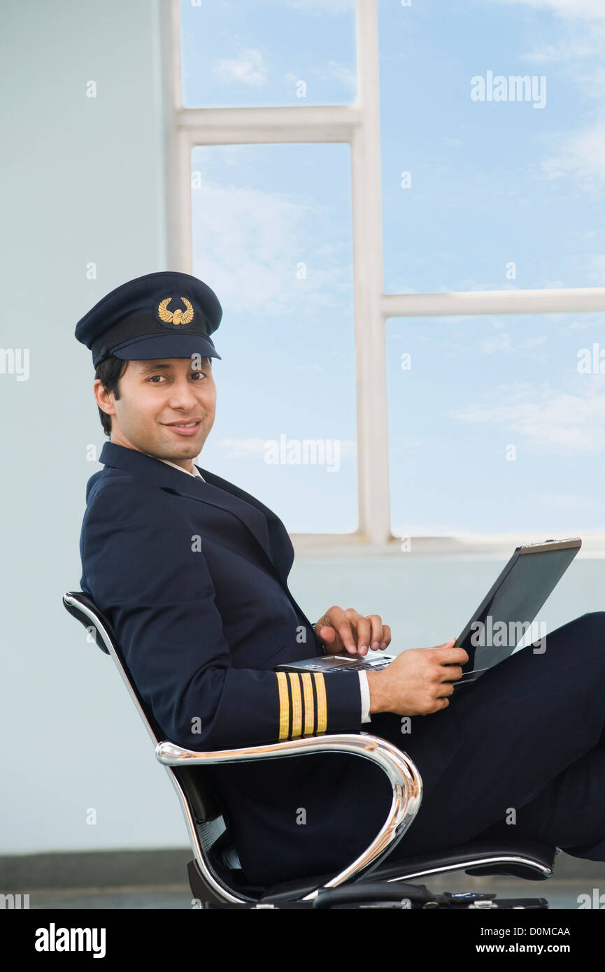 Pilot using a laptop at an airport Stock Photo - Alamy