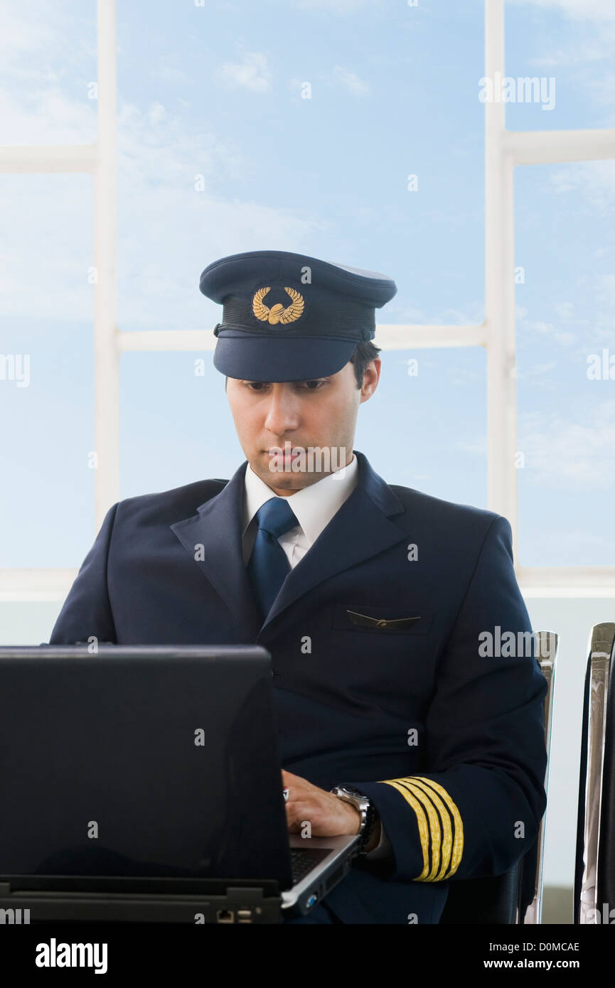 Pilot using a laptop at an airport Stock Photo - Alamy