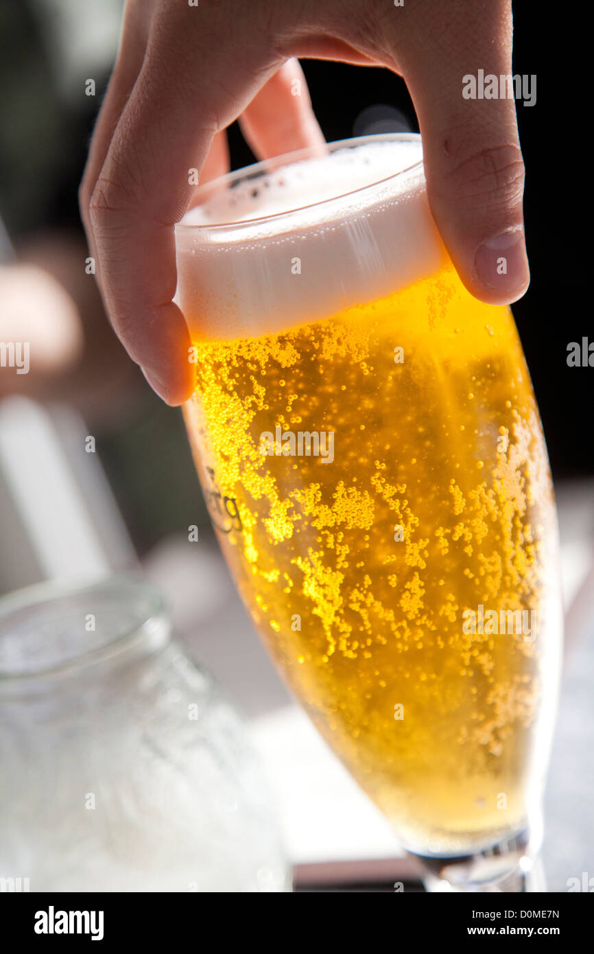 Hand holding glass of beer Stock Photo - Alamy