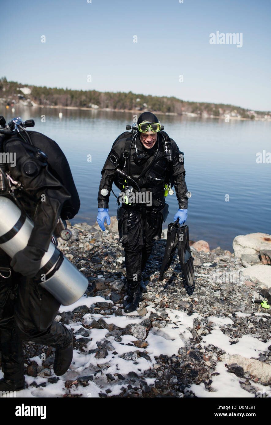Two divers walking out of water Stock Photo - Alamy