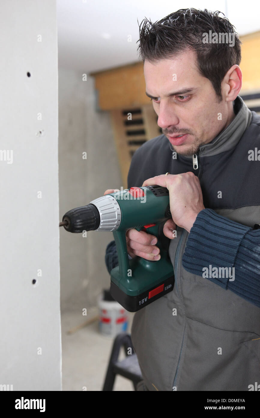Laborer using drill Stock Photo - Alamy