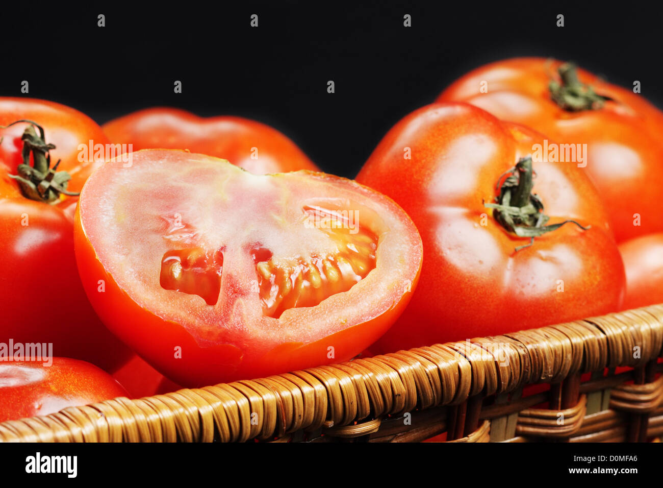 Slit tomato in basket closeup Stock Photo - Alamy