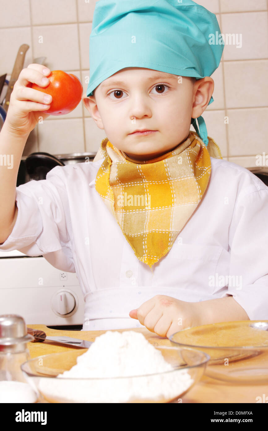 Little cook with tomato Stock Photo - Alamy