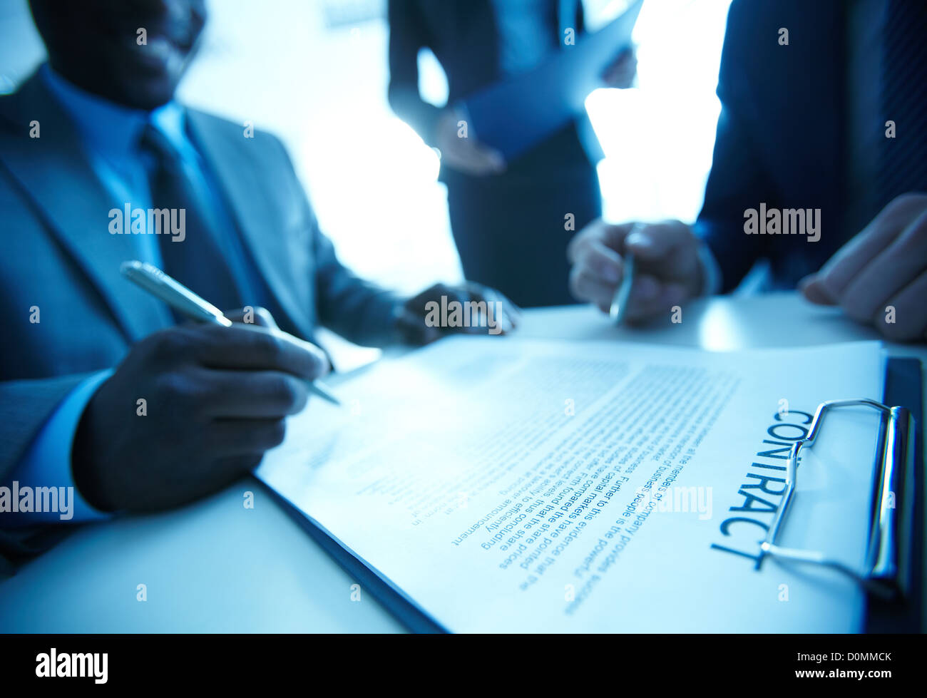 Image of businessman signing contract with two employees near by Stock ...
