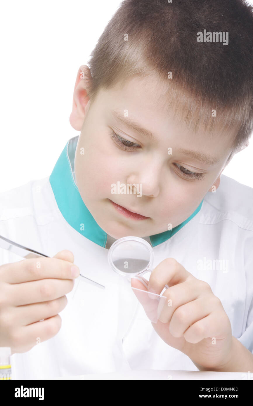 Boy examining object through magnifier Stock Photo - Alamy