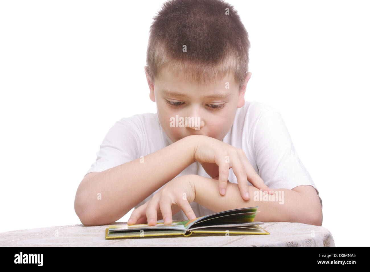 Boy reading book at table Stock Photo - Alamy