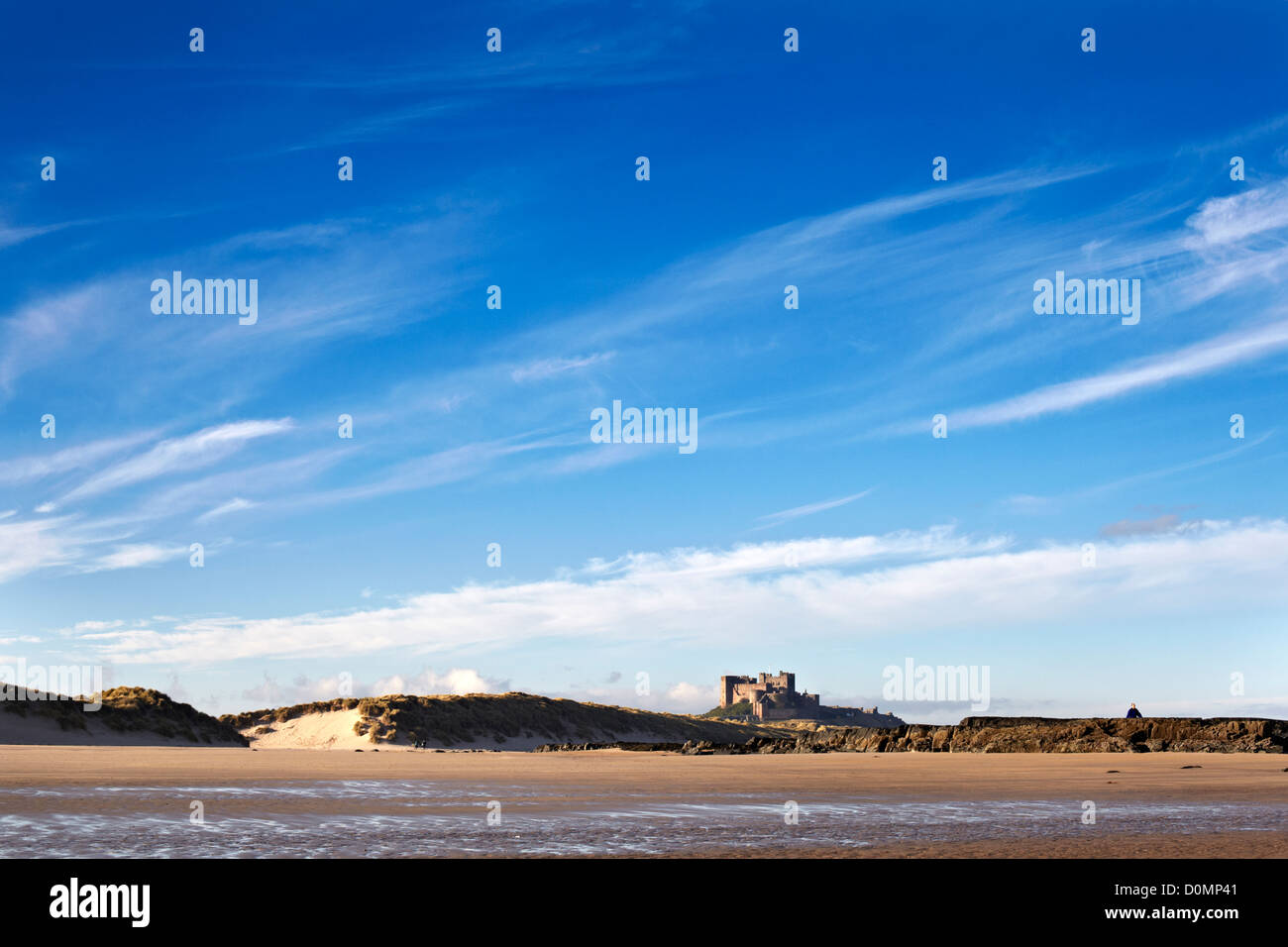 Walk on beach beneath Bamborough Castle. Northumberland Stock Photo - Alamy