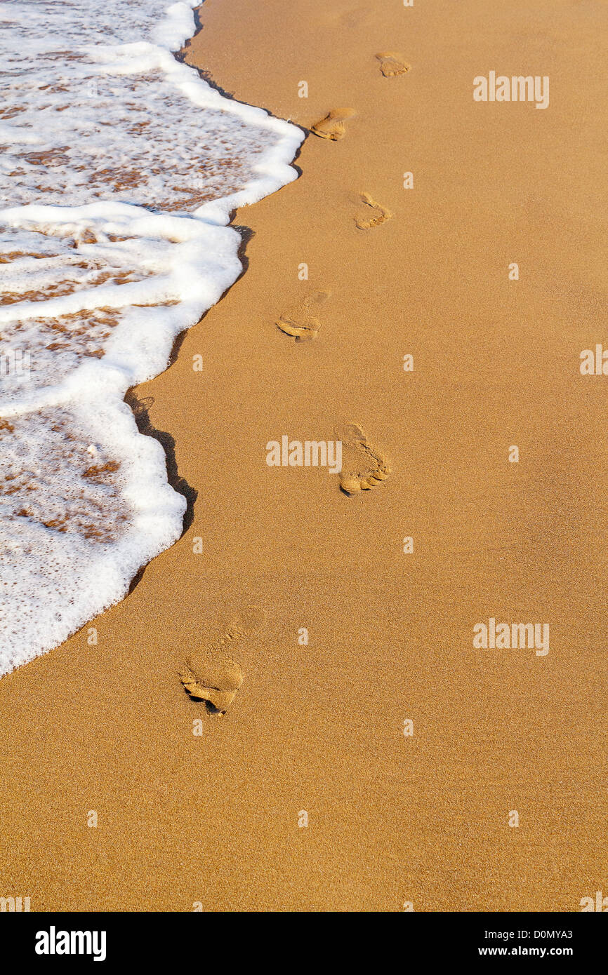 Footsteps on the beach by the sea in summer Stock Photo - Alamy