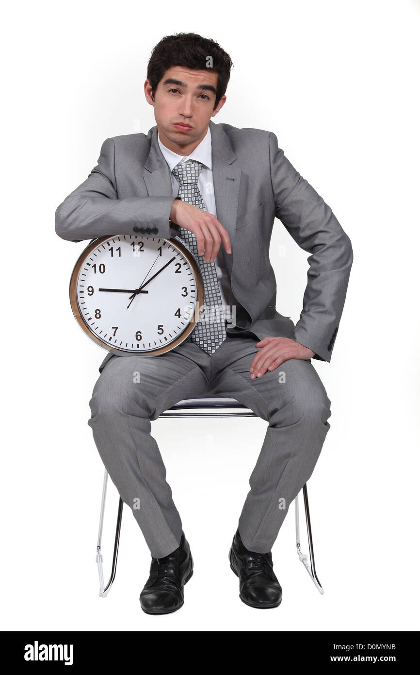 Businessman bored with alarm clock Stock Photo - Alamy