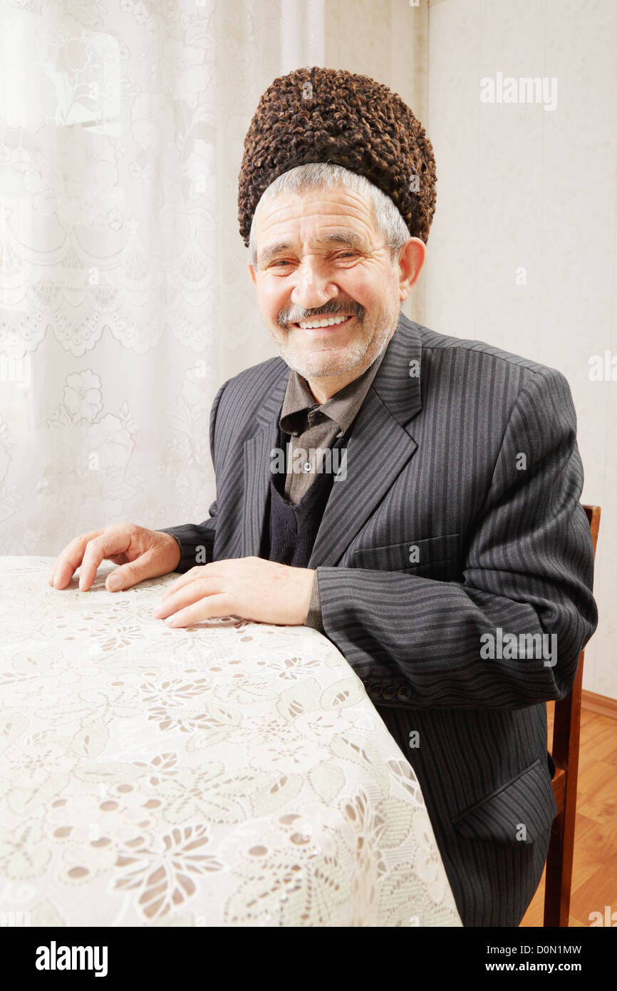 Happy senior man sitting at table Stock Photo - Alamy