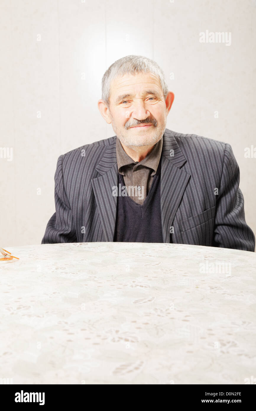 Senior man at table Stock Photo - Alamy