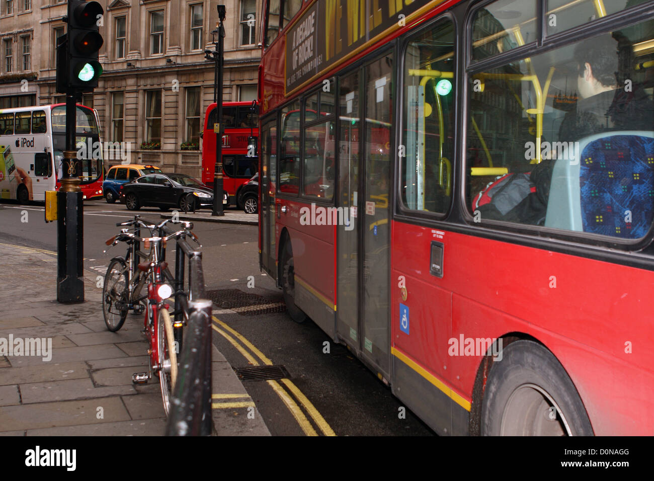 A red London double decker bus passing traffic lights at green Stock ...