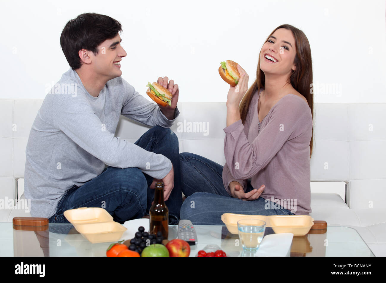Couple eating hamburgers Stock Photo - Alamy