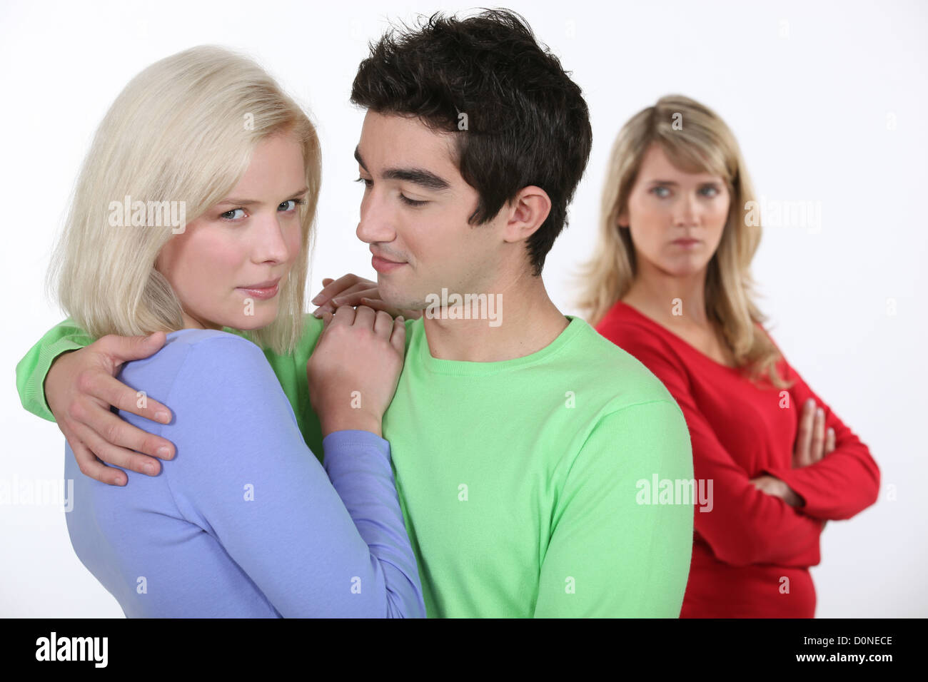 Woman jealous of couple hugging Stock Photo - Alamy