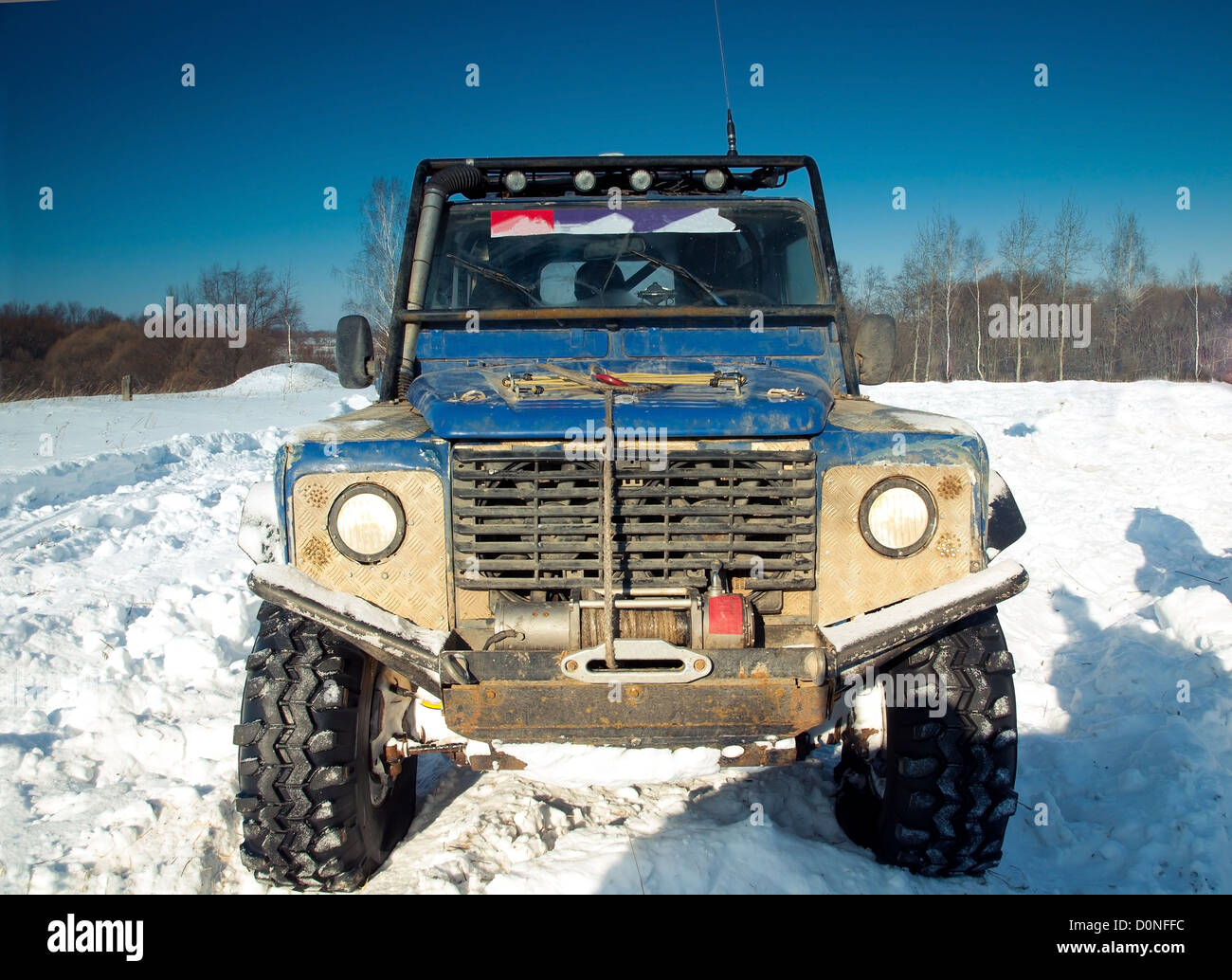 Blue Land Rover Defender 90 suv front on background the Russian winter ...