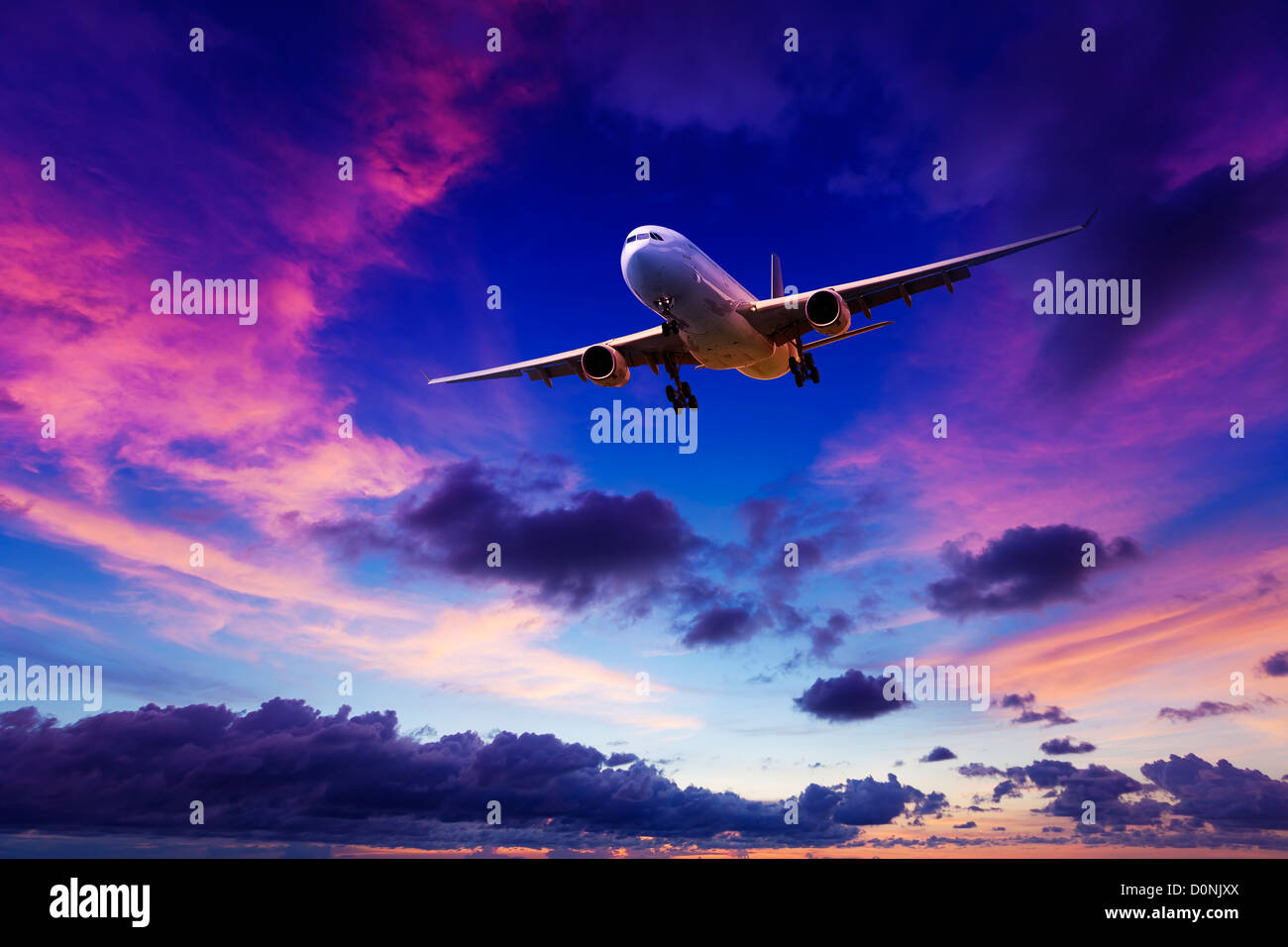 Plane in a sunset sky Stock Photo - Alamy
