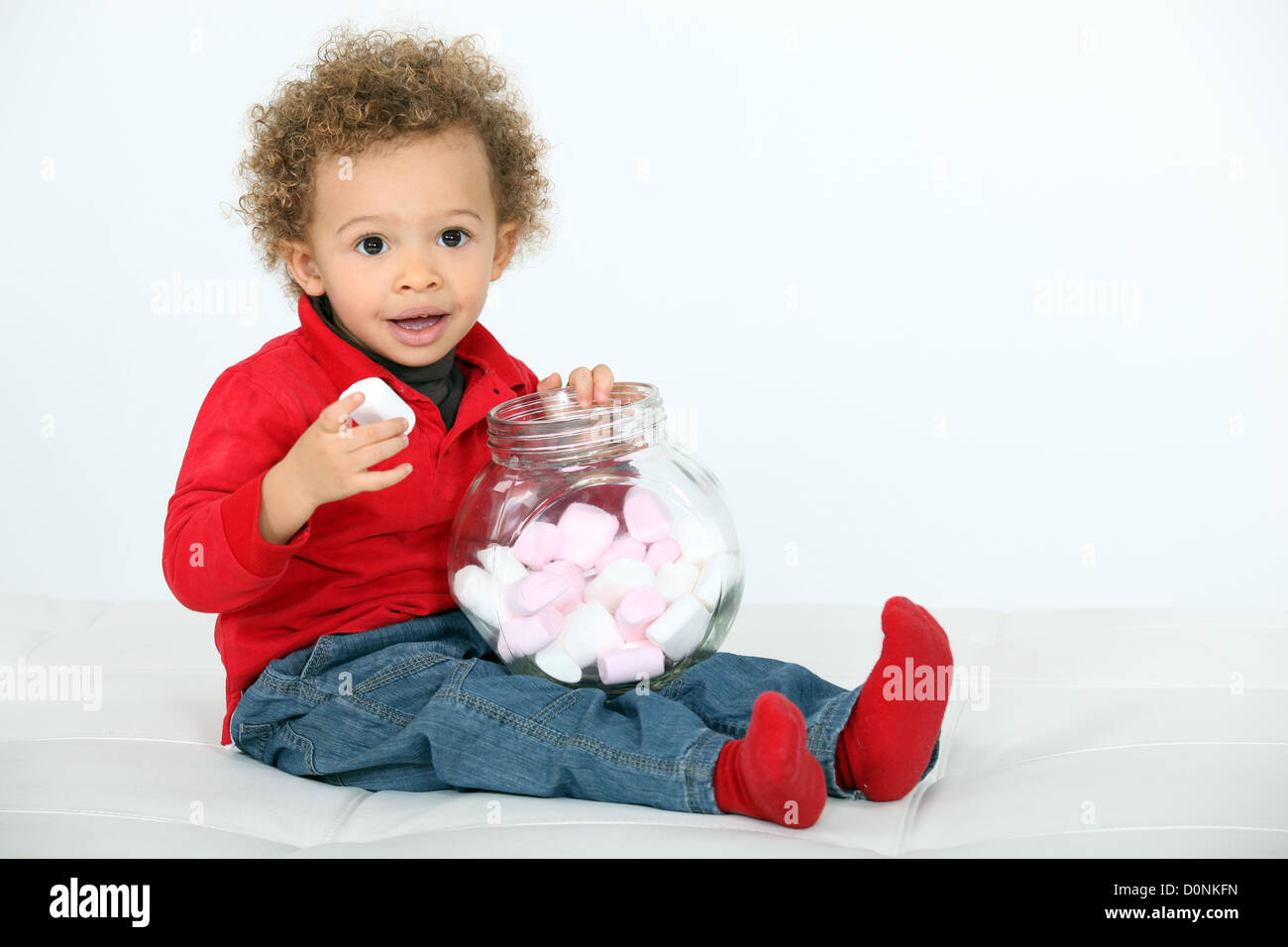 Cute little boy eating marshmallows, studio shot Stock Photo - Alamy