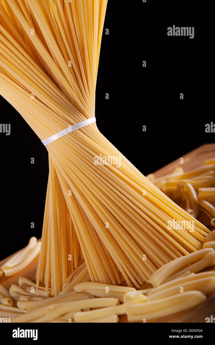 A bunch of long spaghetti pasta over dark background Stock Photo - Alamy
