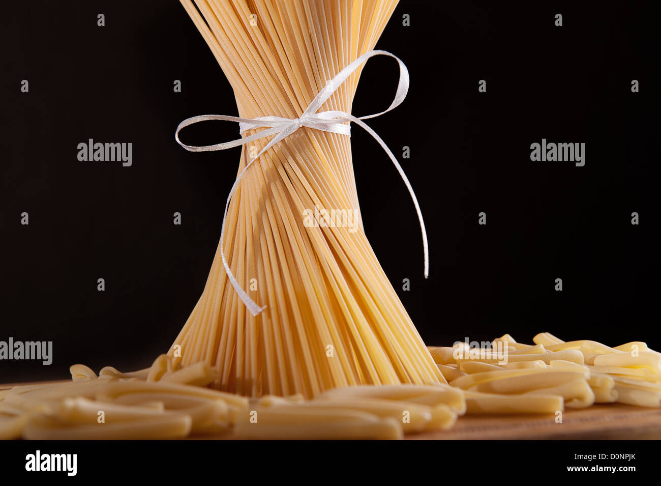 Ribbon tied bunch of spaghetti pasta over black background Stock Photo ...