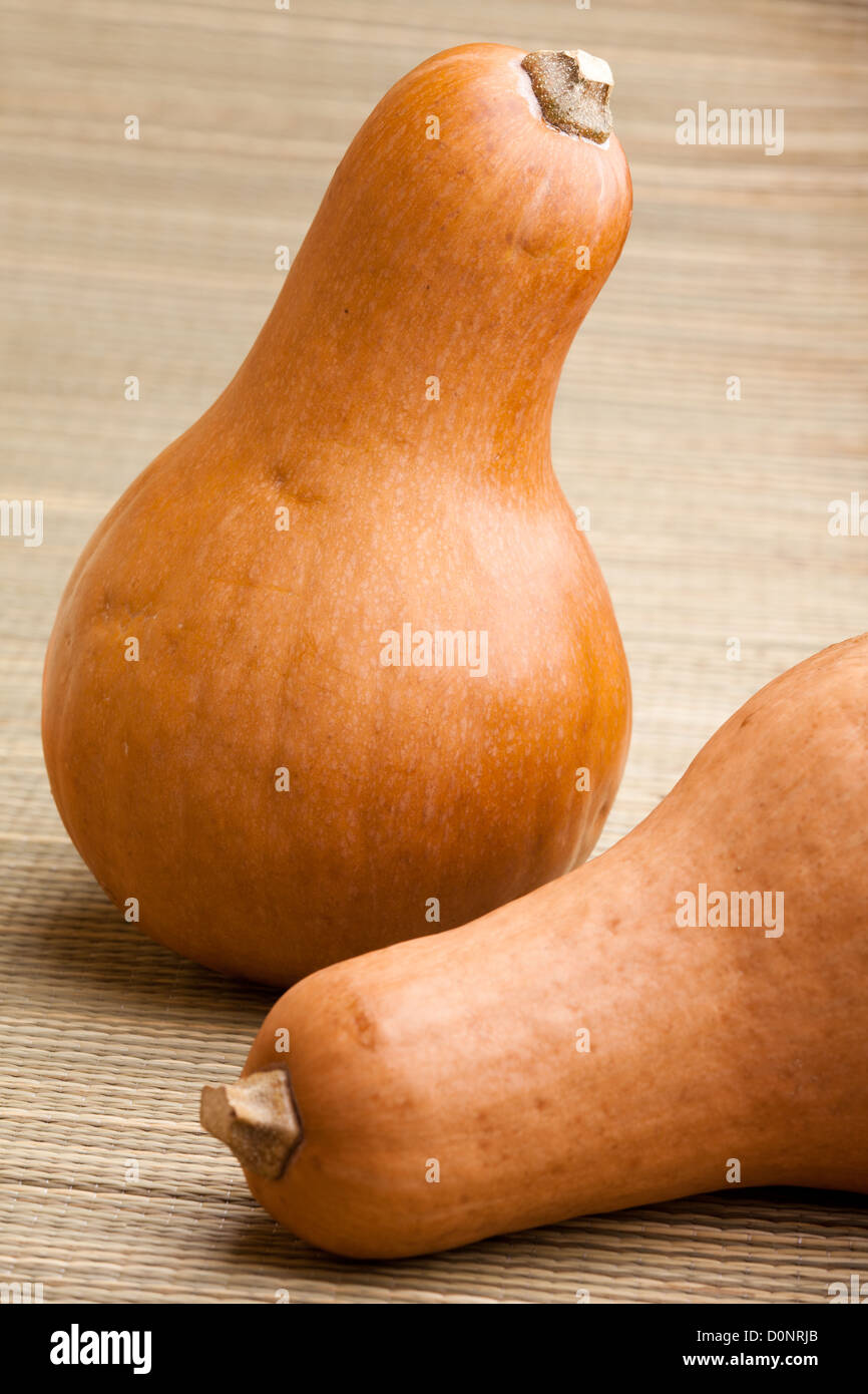 Group of ripe orange gourds on rural straw woven surface and stripy ...