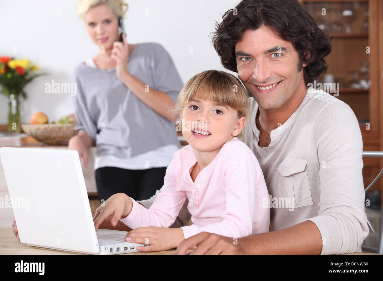 Parents and little girl with laptop Stock Photo - Alamy