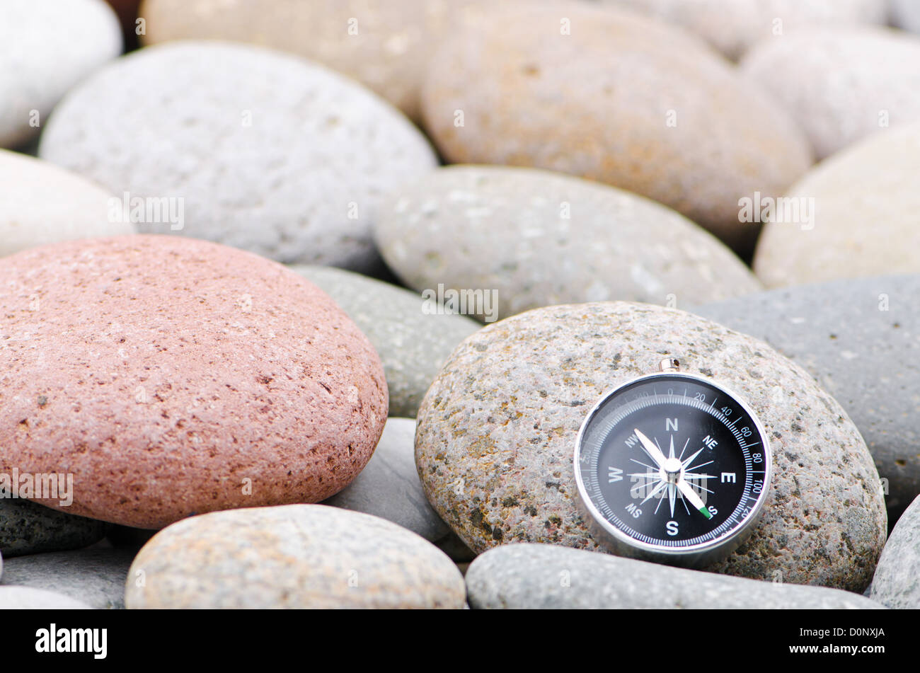 Navigation compass on stone pebbles Stock Photo - Alamy