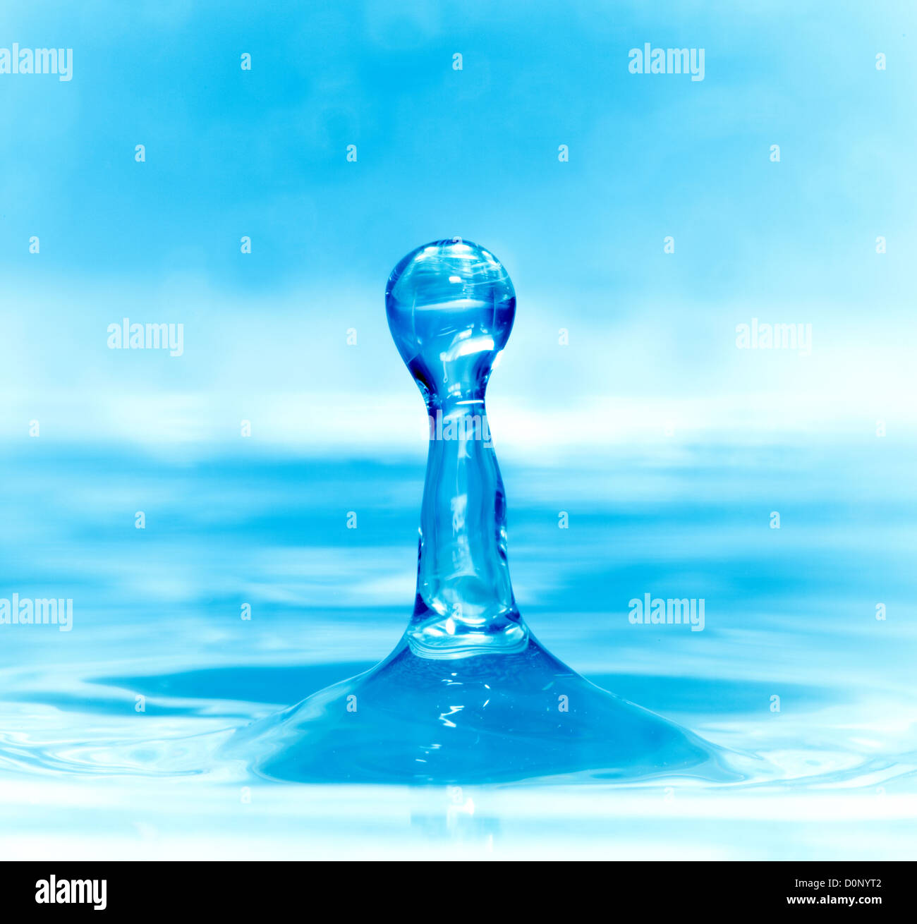 Falling drop of blue water Stock Photo - Alamy