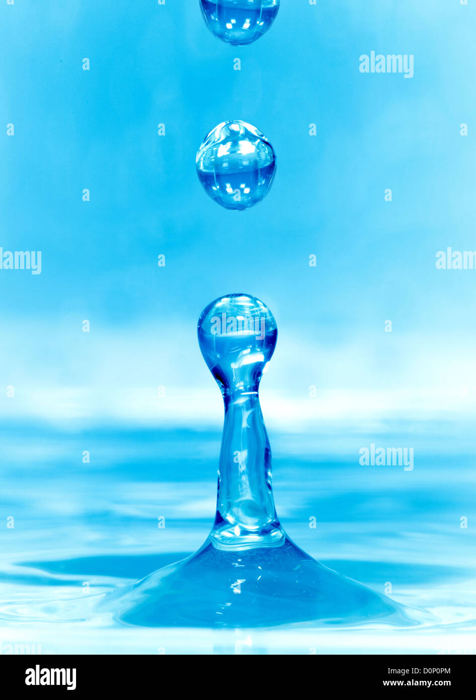 Falling drop of blue water Stock Photo - Alamy