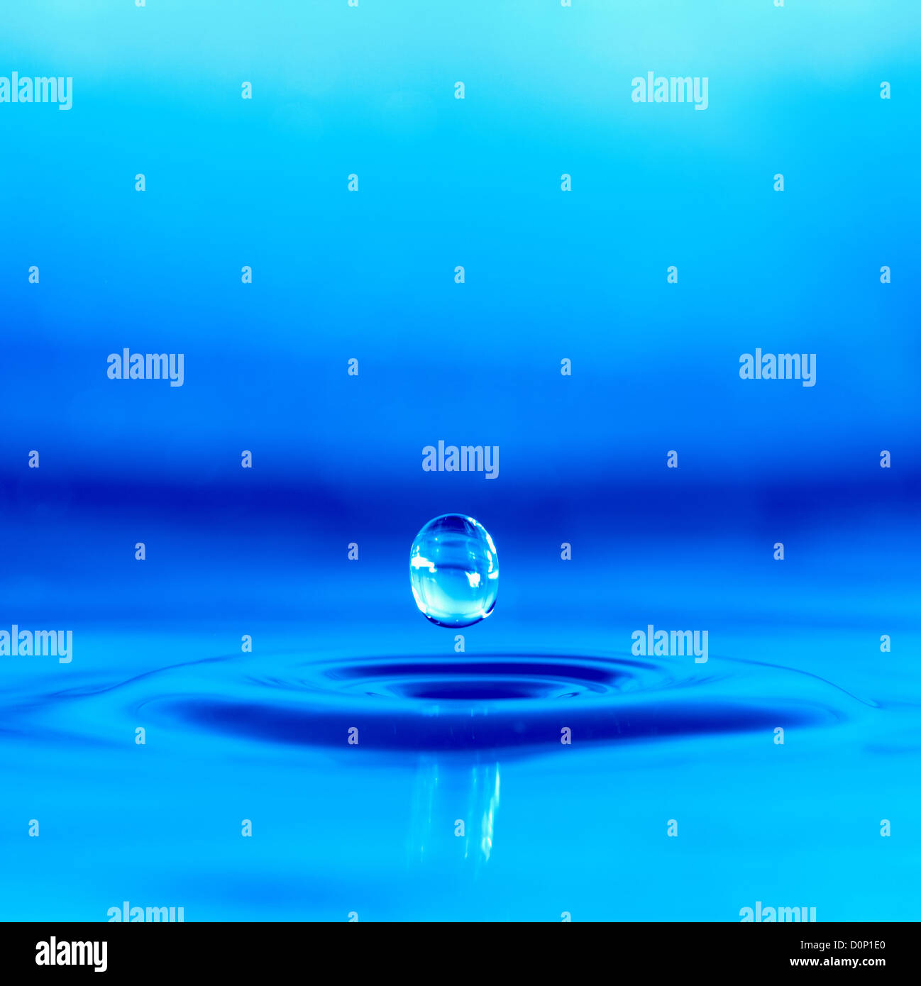 Falling drop of blue water Stock Photo - Alamy