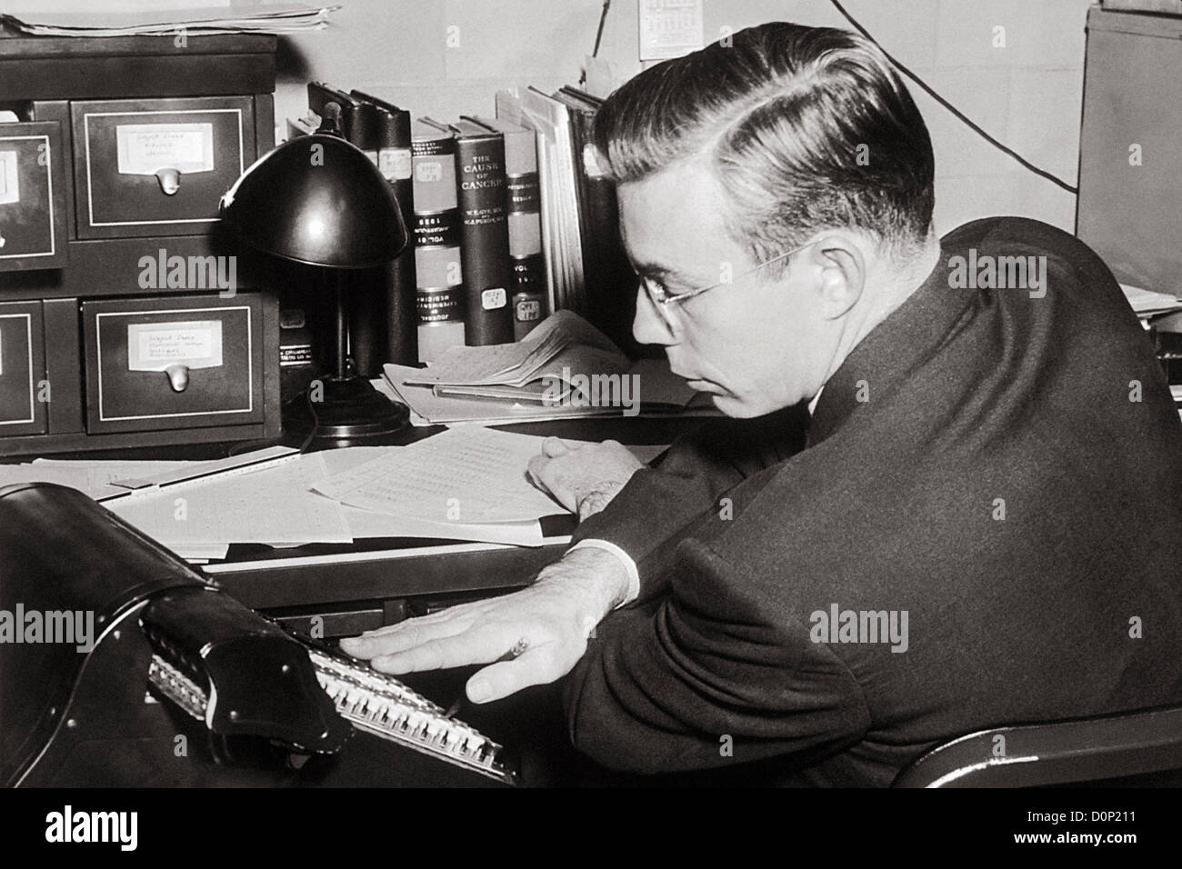 A scientist seated at a desk working on scientific calculations Stock ...