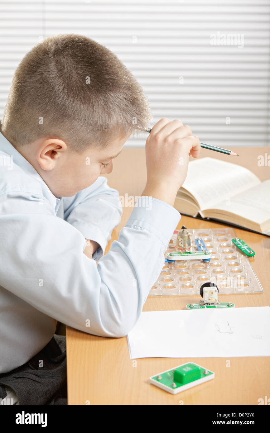 Puzzled boy looking at curcuit Stock Photo - Alamy