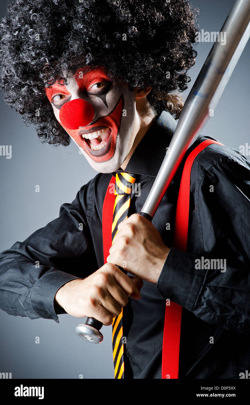 Funny clown with bat in studio Stock Photo - Alamy