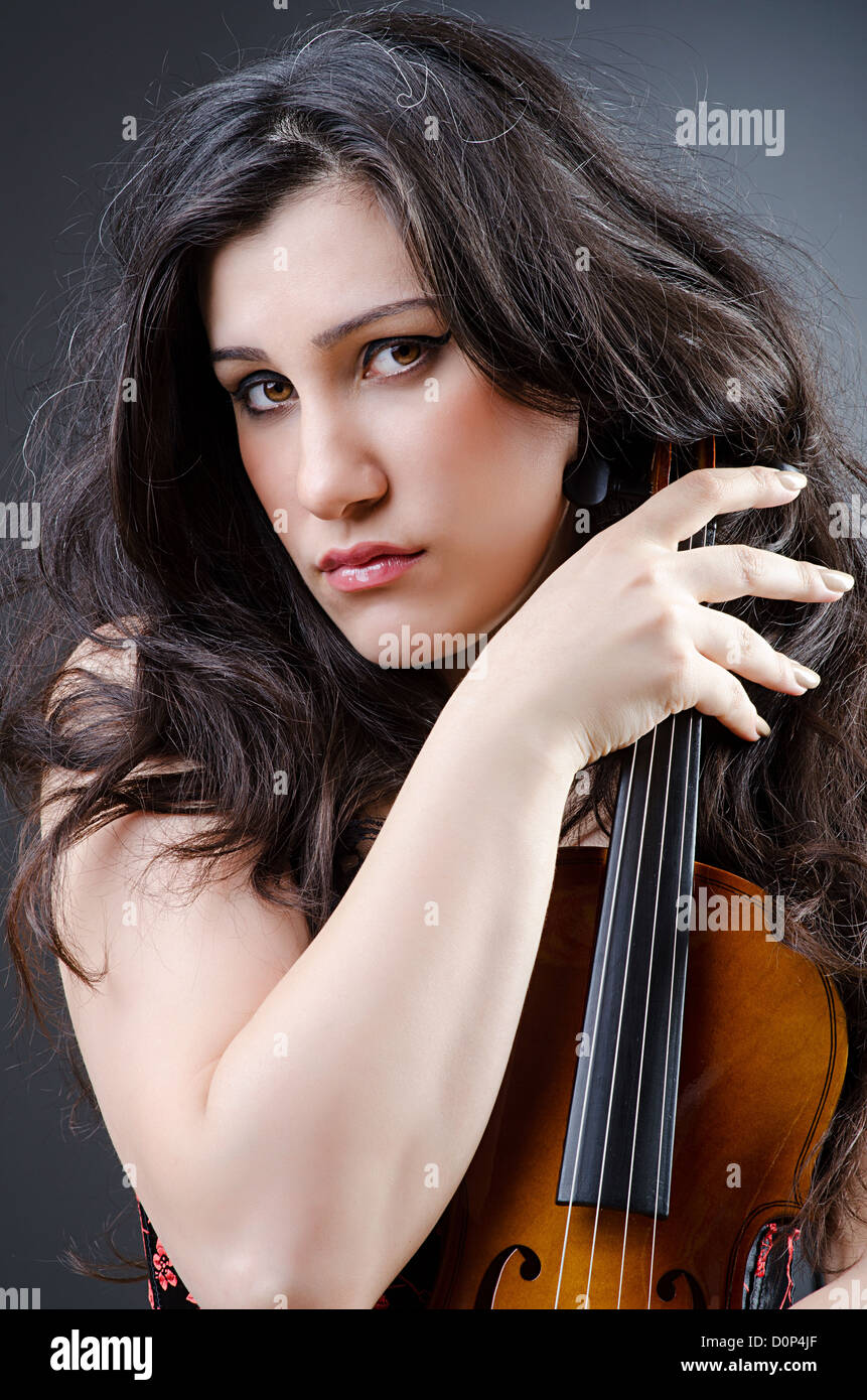 Female violin player against background Stock Photo - Alamy