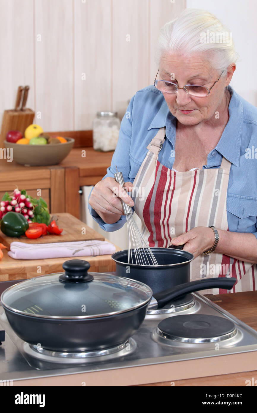 Senior woman cooking Stock Photo - Alamy