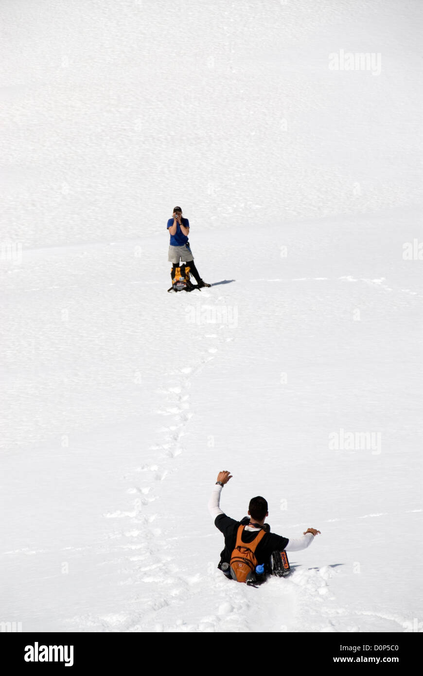 Hikers sliding down snowfield on Cerro Teta, in the Andes Mountains of ...