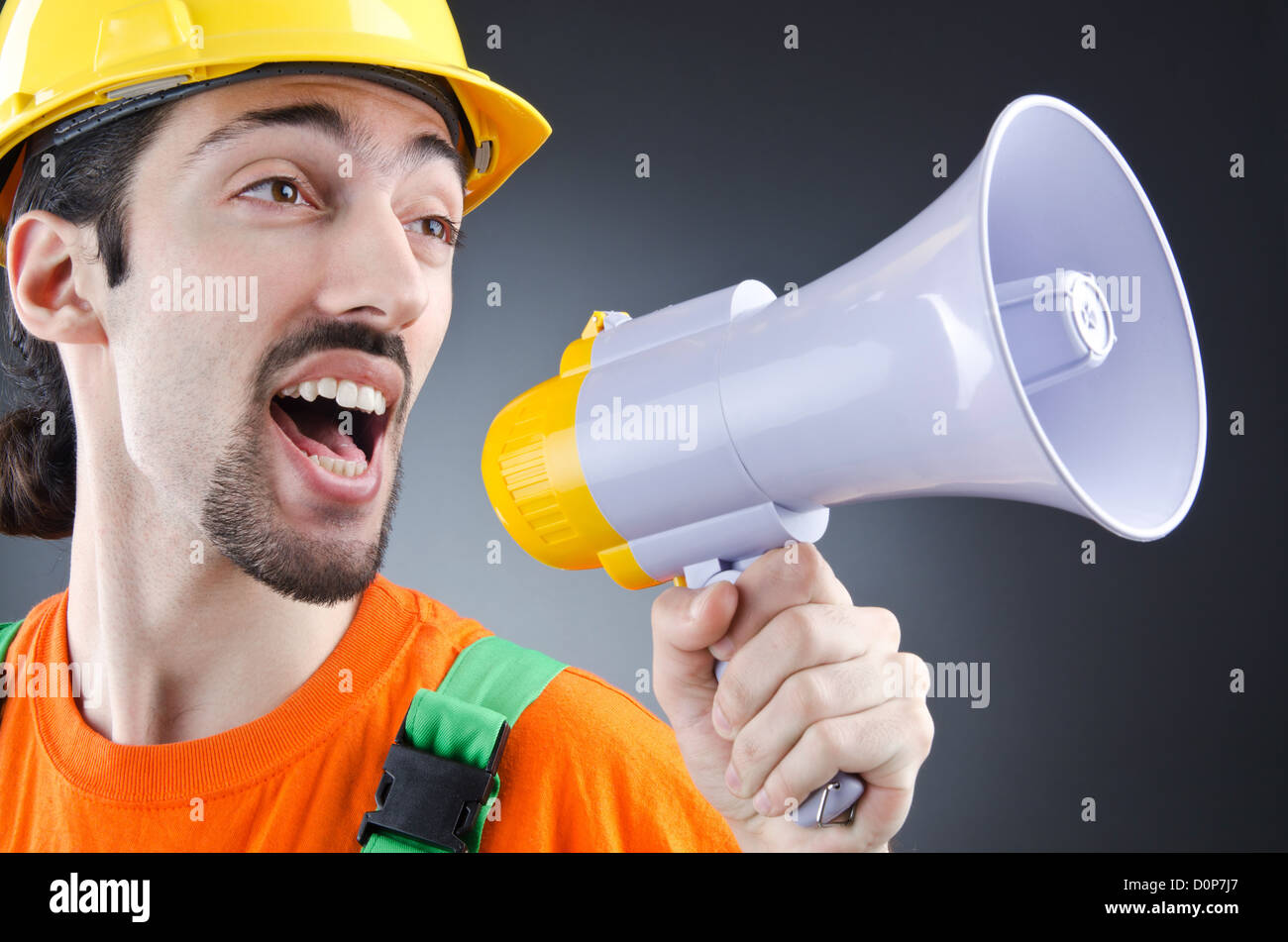 Construction worker with loudspeaker in studio Stock Photo - Alamy