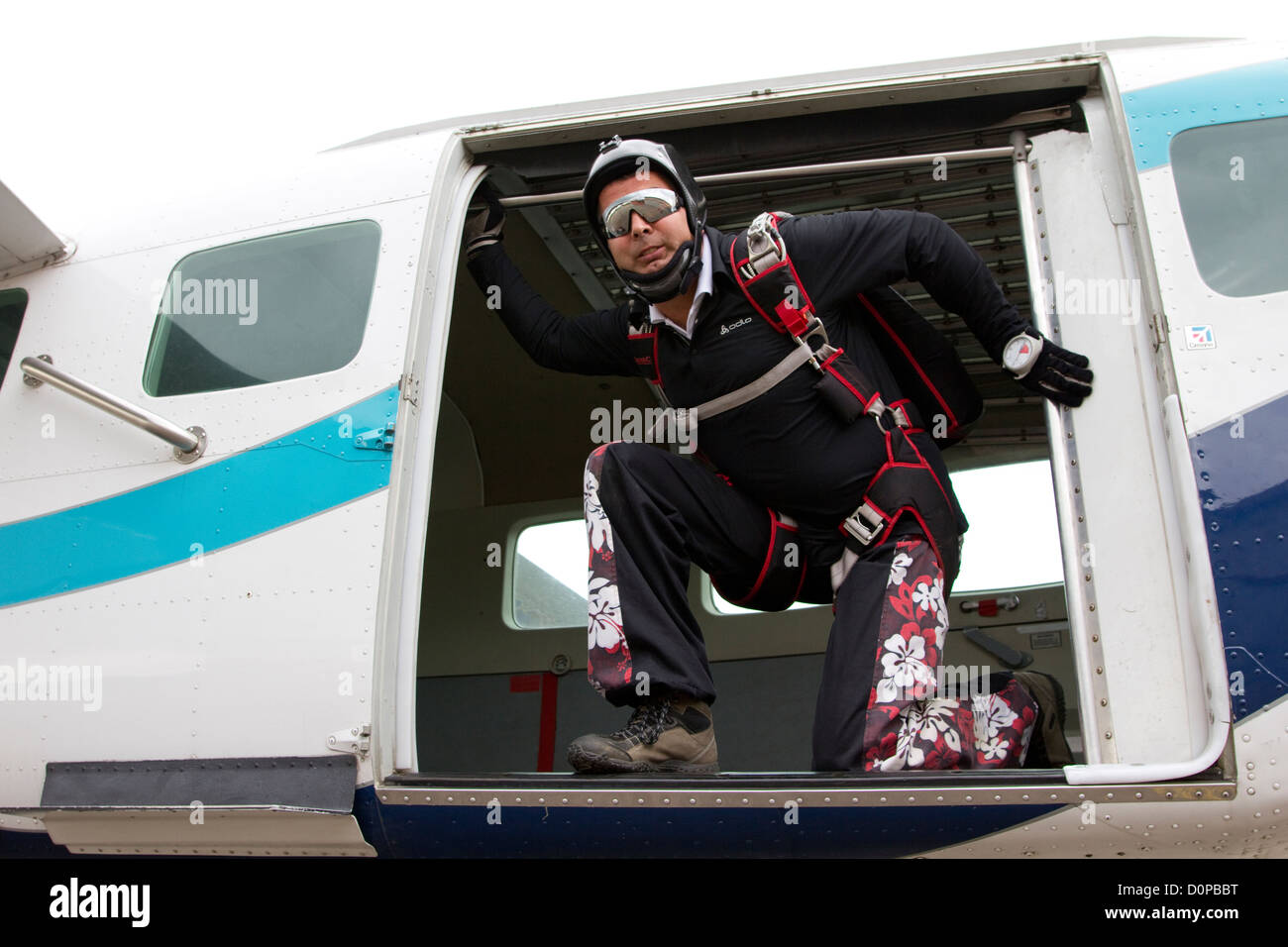Man over 55 years is preparing himself for a skydive jump. Thereby he's ...