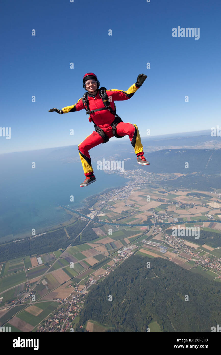 This skydiver is training a sit position over a beautiful lake and ...
