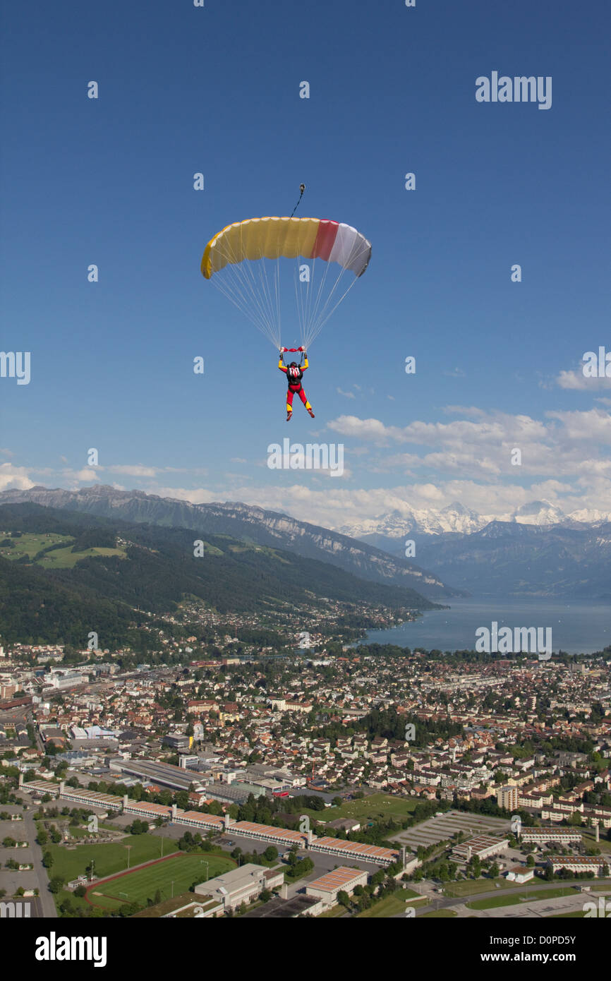 Skydiver under canopy is flying over big city and is looking out for a ...