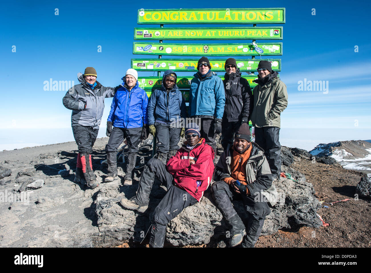 MOUNT KILIMANJARO, Tanzania — A group of climbers pose for a photo next to the sign marking ...