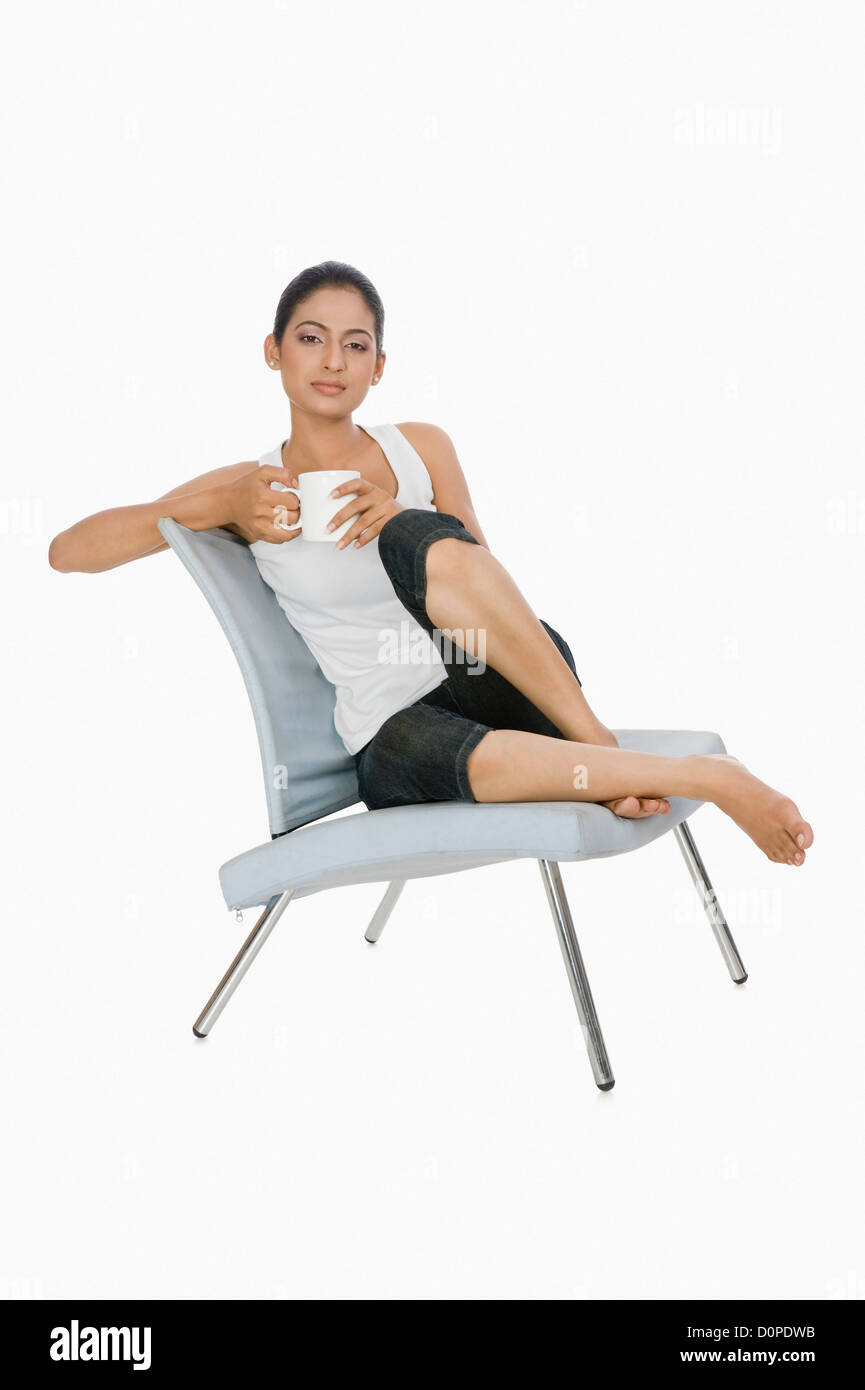 Woman sitting on a chair and drinking tea Stock Photo - Alamy