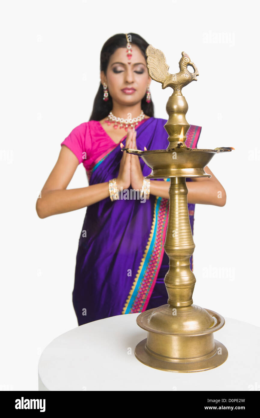 Woman praying with oil lamp in front of her Stock Photo - Alamy