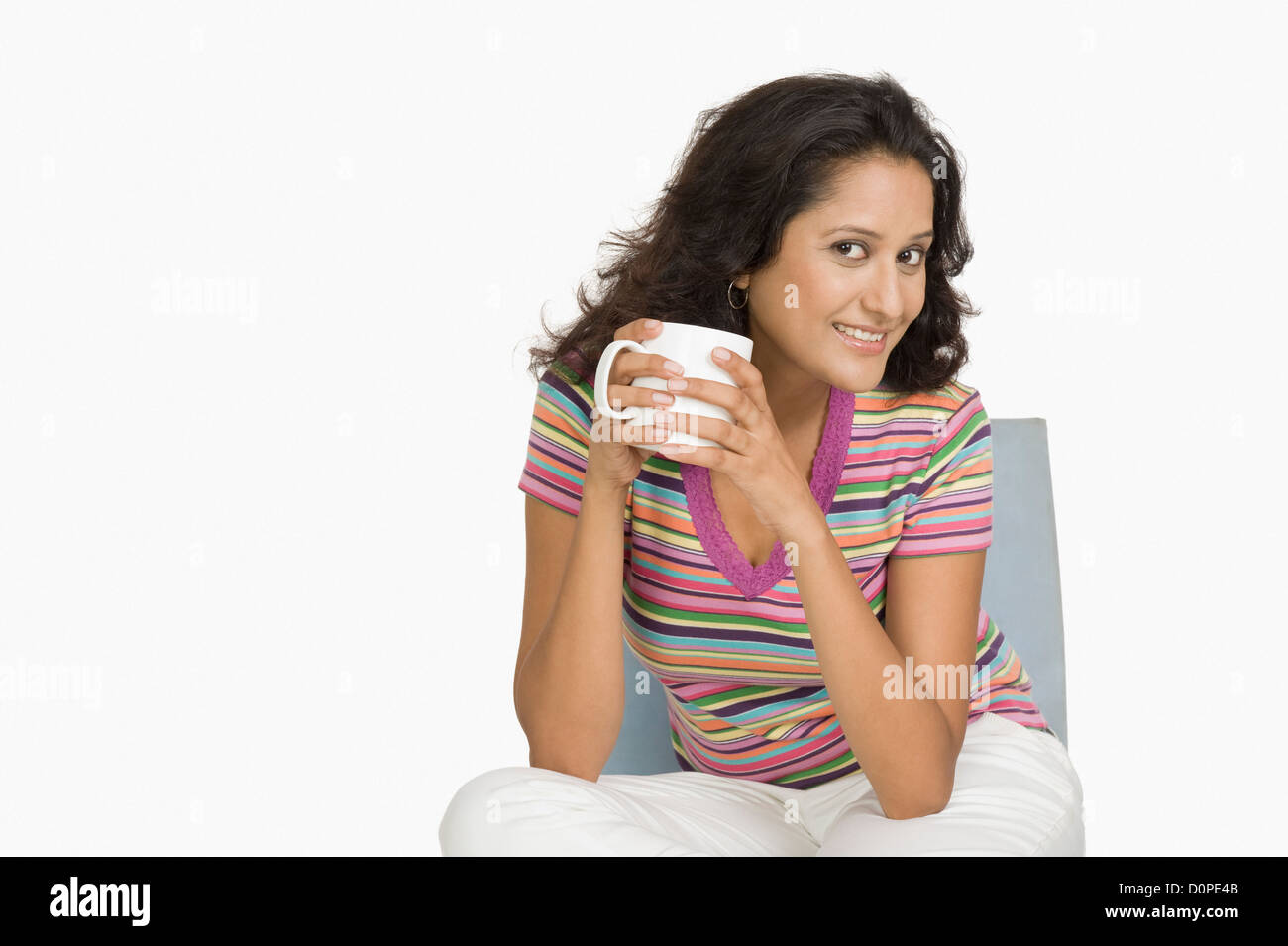 Woman sitting on a chair and drinking tea Stock Photo - Alamy