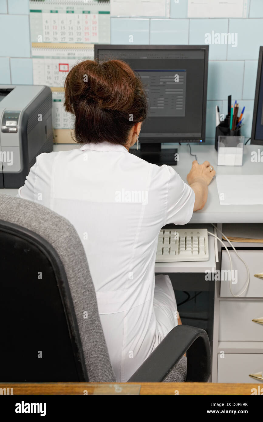 Doctor working at computer rear view Stock Photo - Alamy