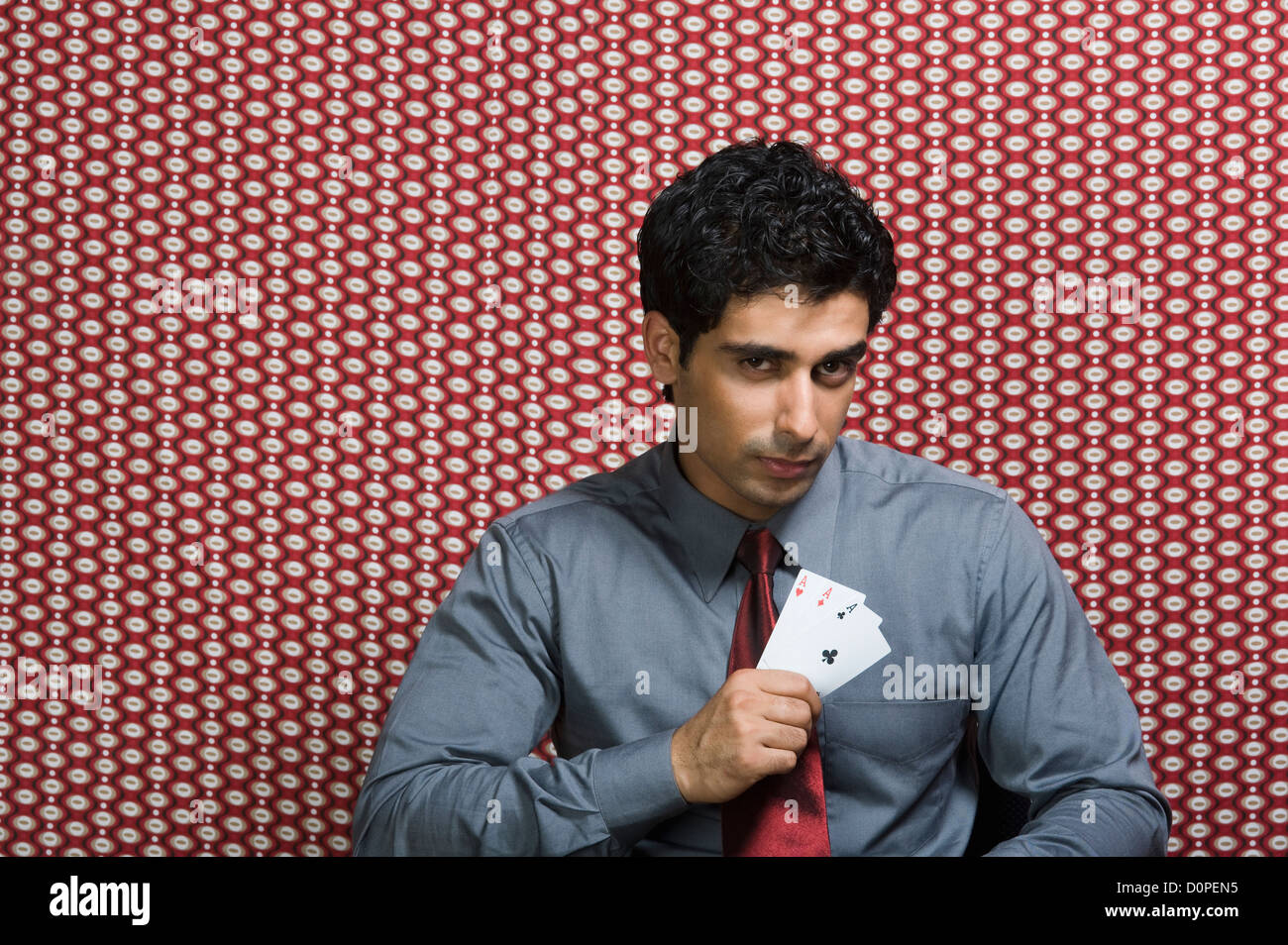 Portrait of a man holding three aces Stock Photo - Alamy