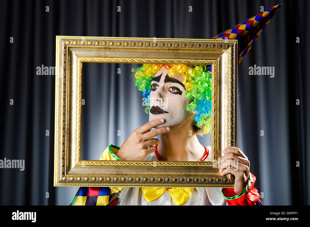 Clown with picture frames in studio Stock Photo - Alamy